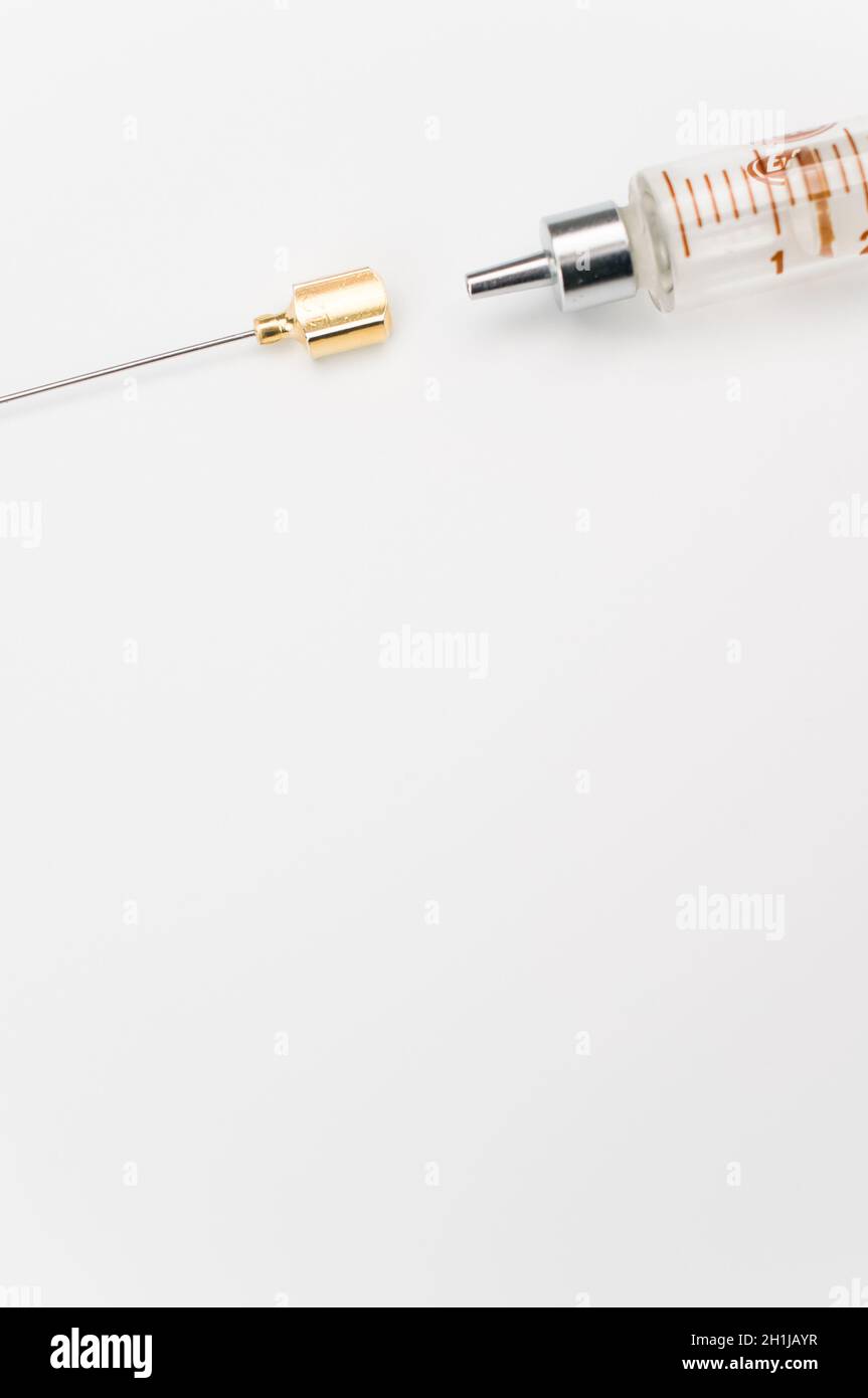 isolated sterilized glass injection syringe on a white paper background ...