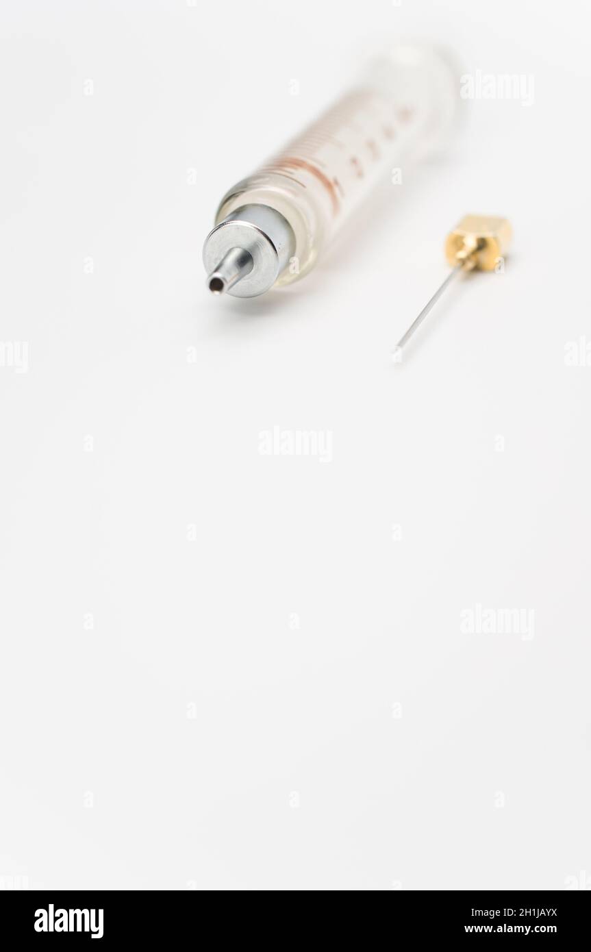 isolated sterilized glass injection syringe on a white paper background ...