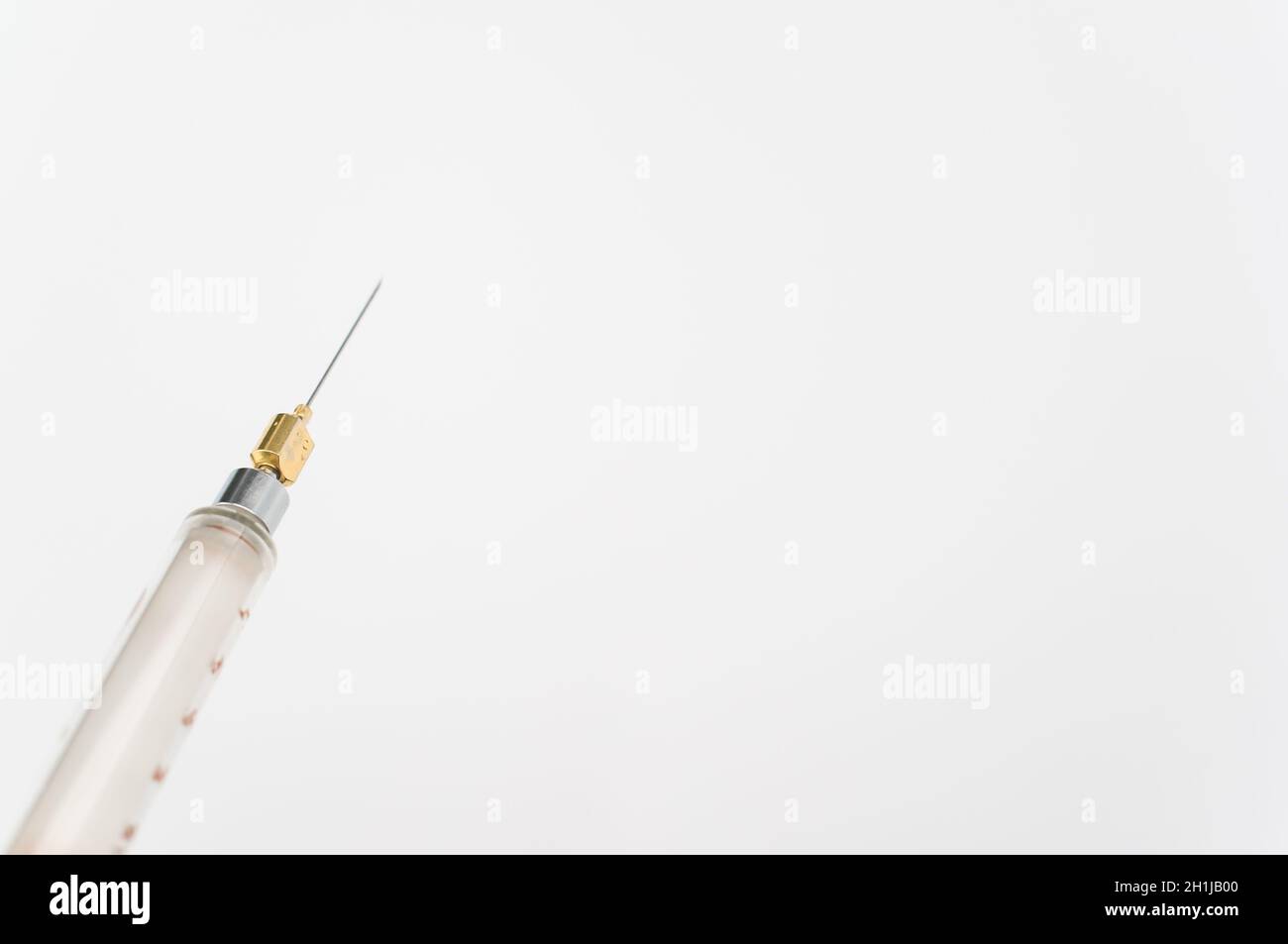 isolated sterilized glass injection syringe on a white paper background ...