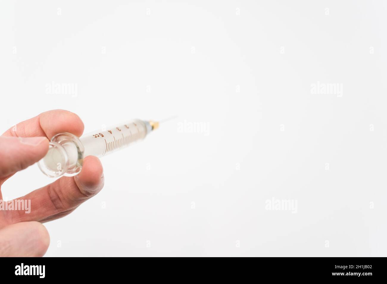 isolated sterilized glass injection syringe on a white paper background ...