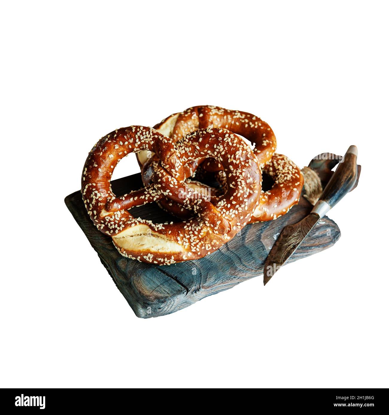 Brezel on a textured board with a knife. Delicious Bavarian pretzel ...