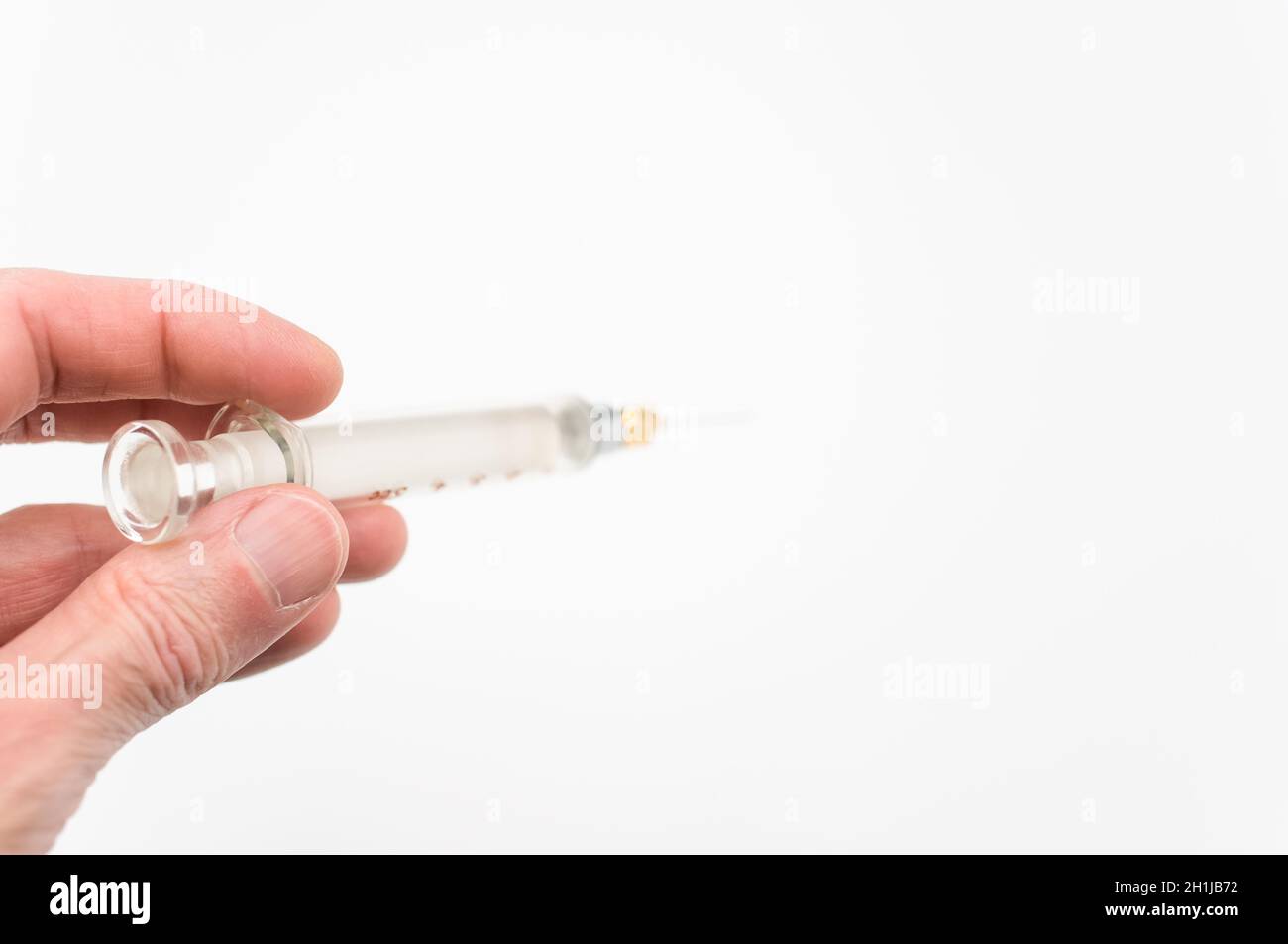 isolated sterilized glass injection syringe on a white paper background ...