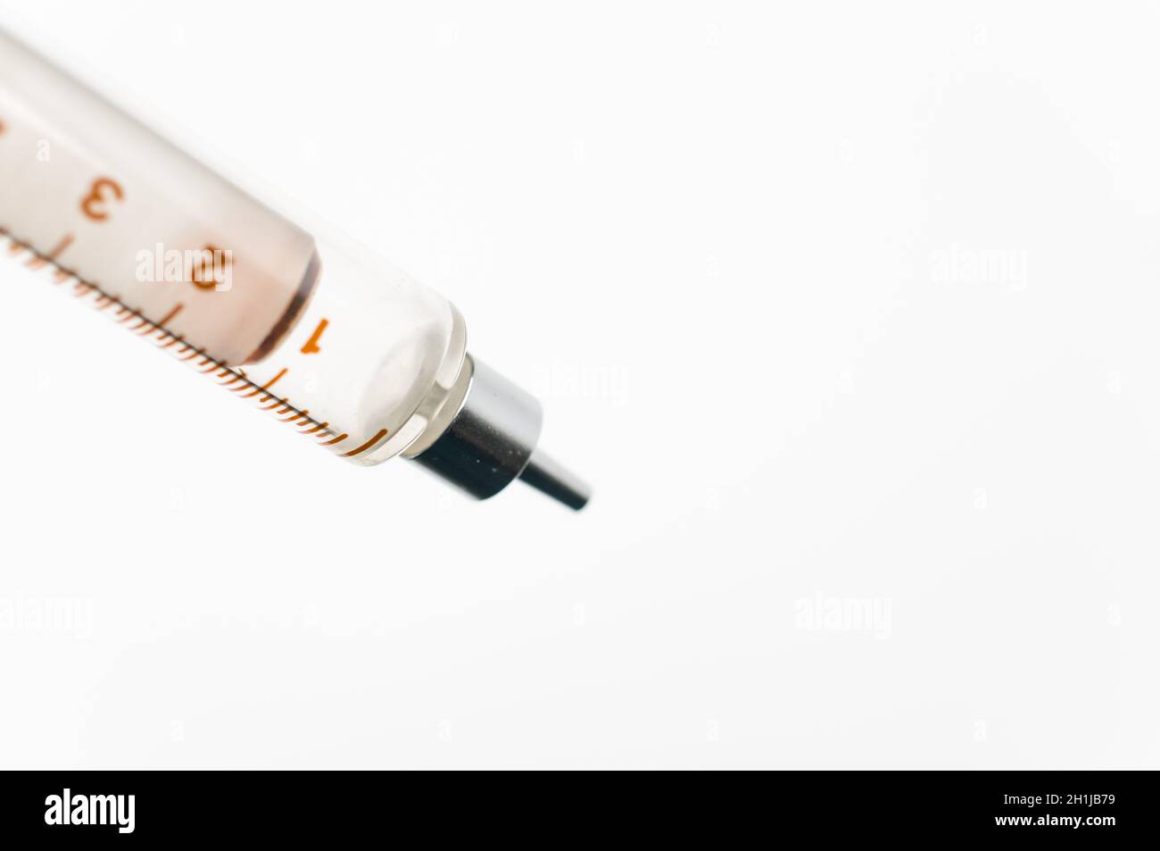 isolated sterilized glass injection syringe on a white paper background ...
