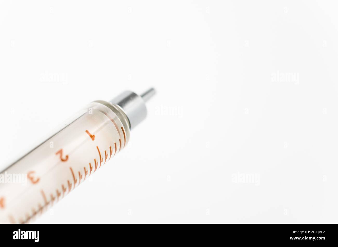 isolated sterilized glass injection syringe on a white paper background ...