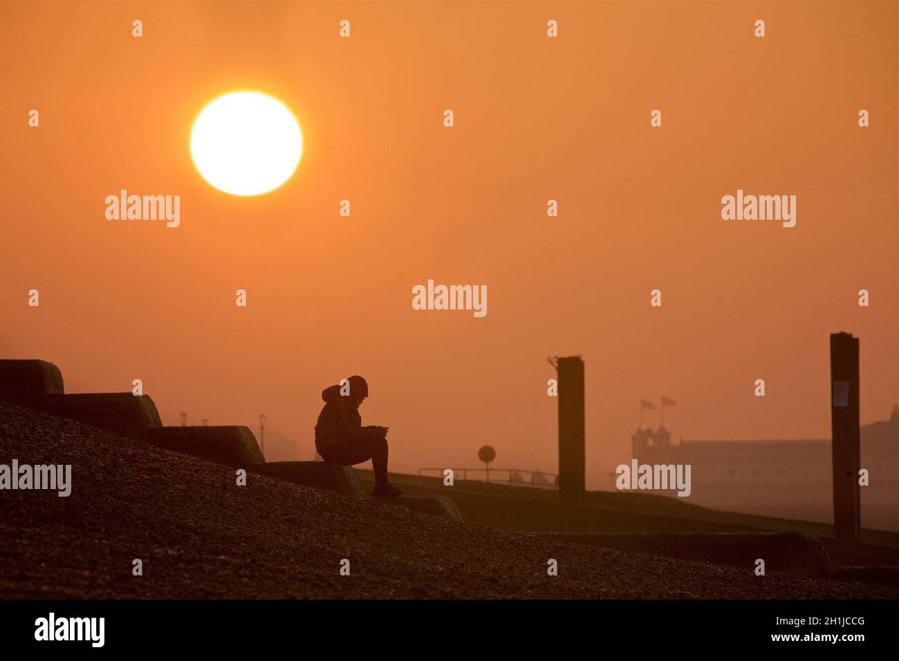 Early morning, Brighton beach. Sunrise. Silhouetted shape of man ...