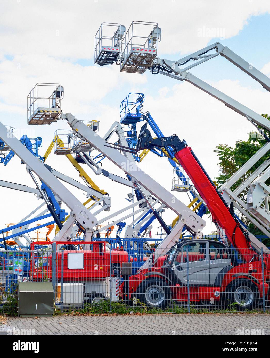 Colorful aerial platform cranes, machines and working equipment in ...