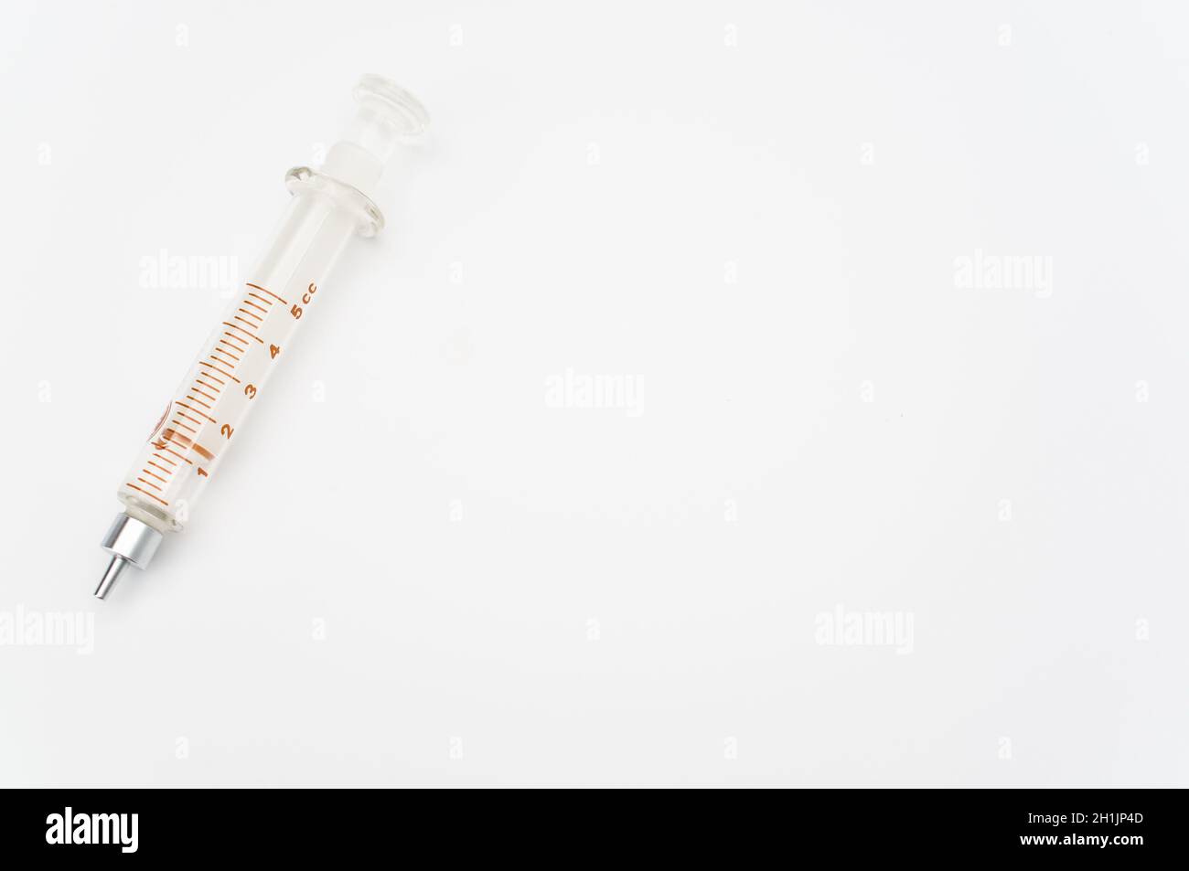 isolated sterilized glass injection syringe on a white paper background ...