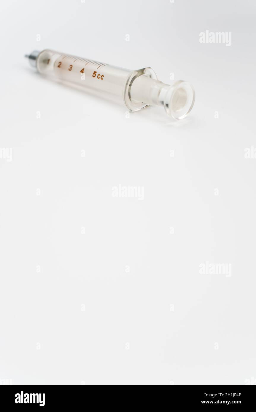 isolated sterilized glass injection syringe on a white paper background ...