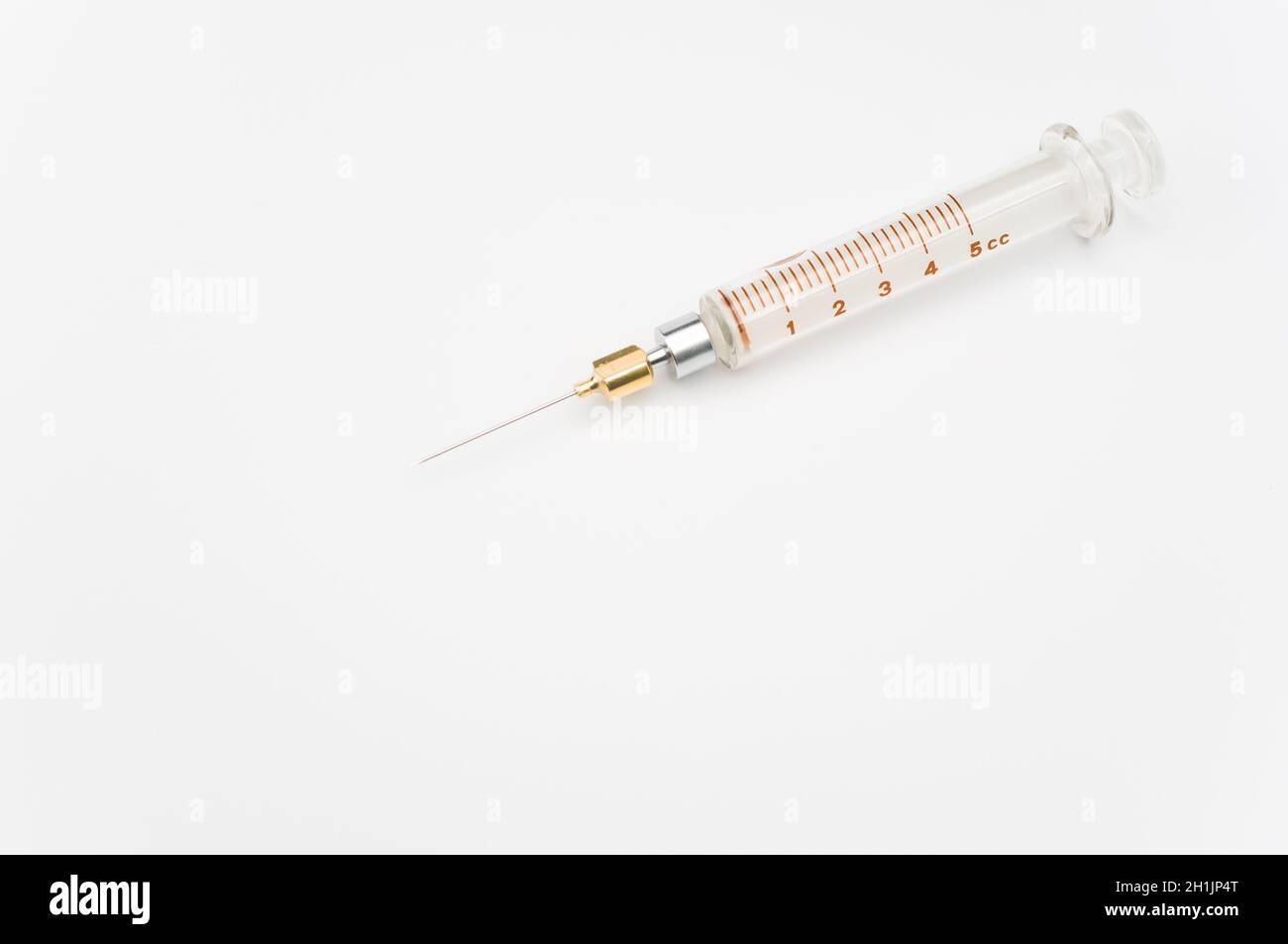 isolated sterilized glass injection syringe on a white paper background ...