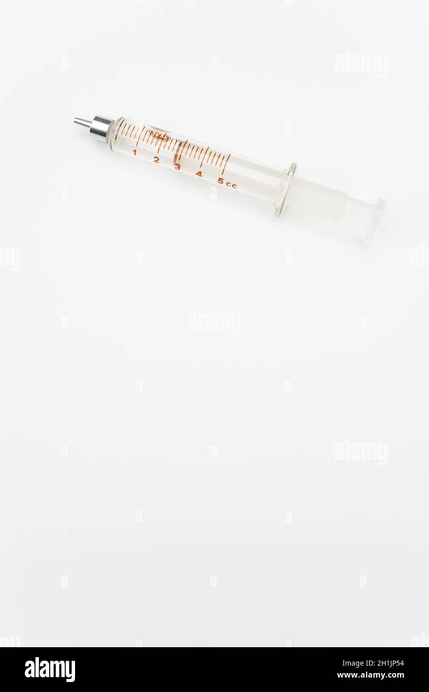 isolated sterilized glass injection syringe on a white paper background ...