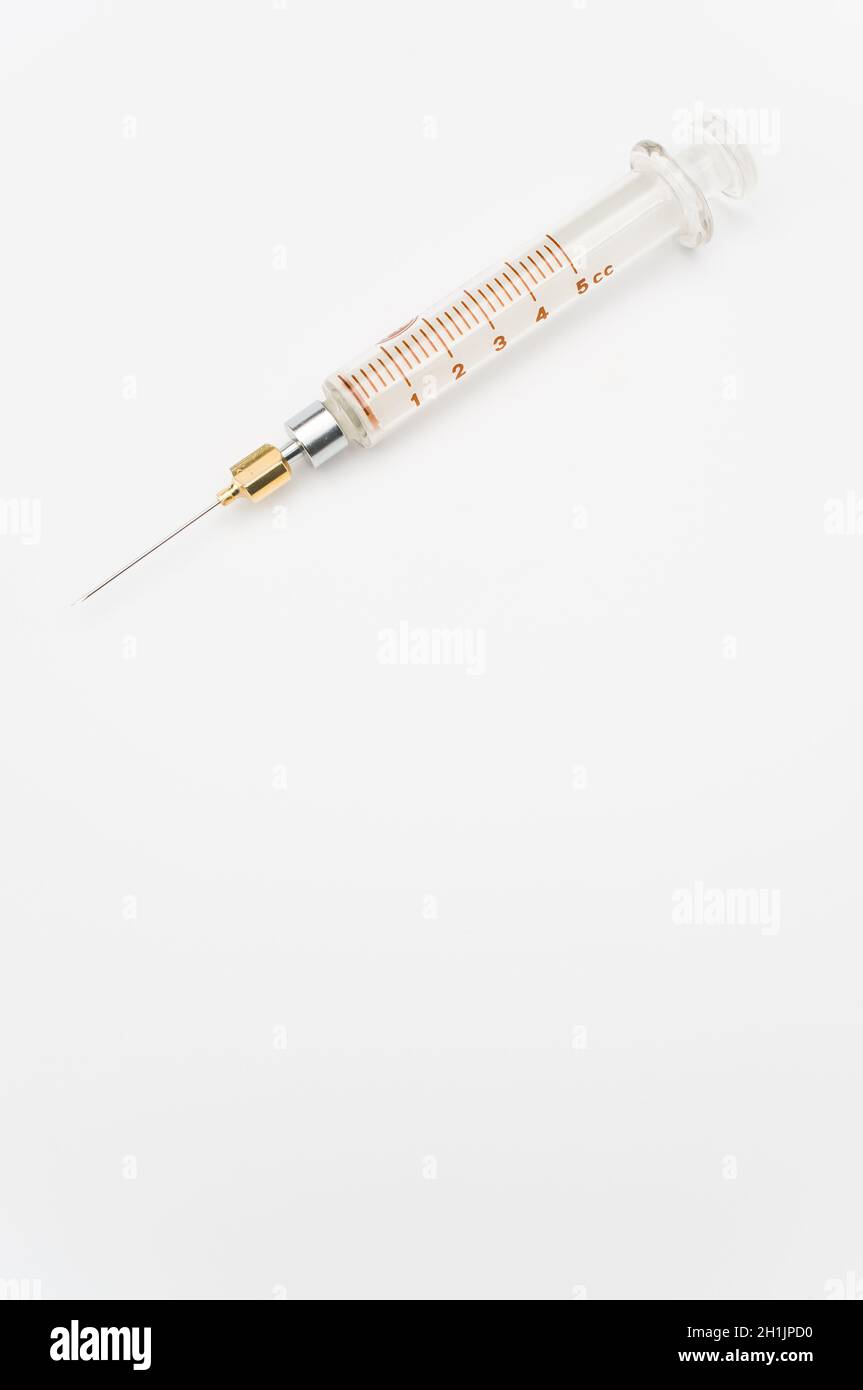 isolated sterilized glass injection syringe on a white paper background ...