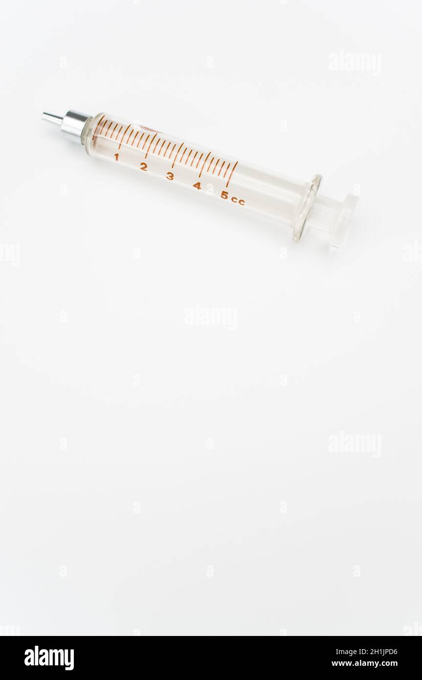 isolated sterilized glass injection syringe on a white paper background ...