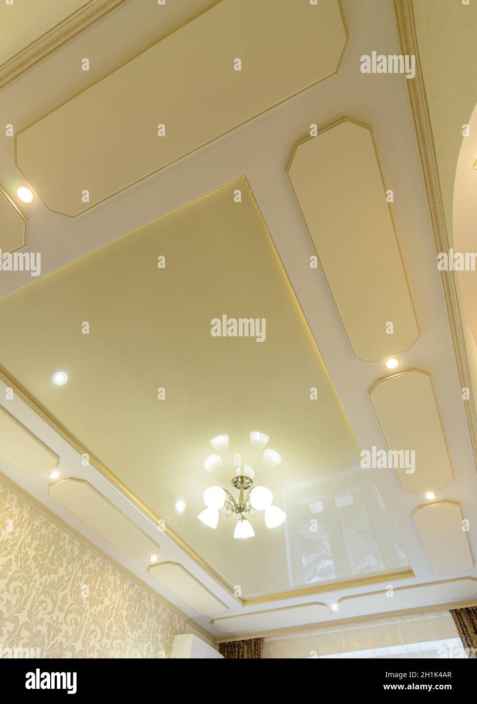 Original stylish multi-level ceiling in gold tones in the bedroom Stock ...