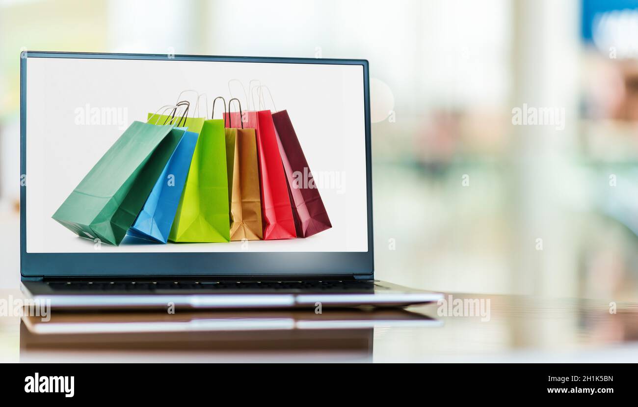 Paper shopping bags on laptop computer screen. Shopping online. E ...