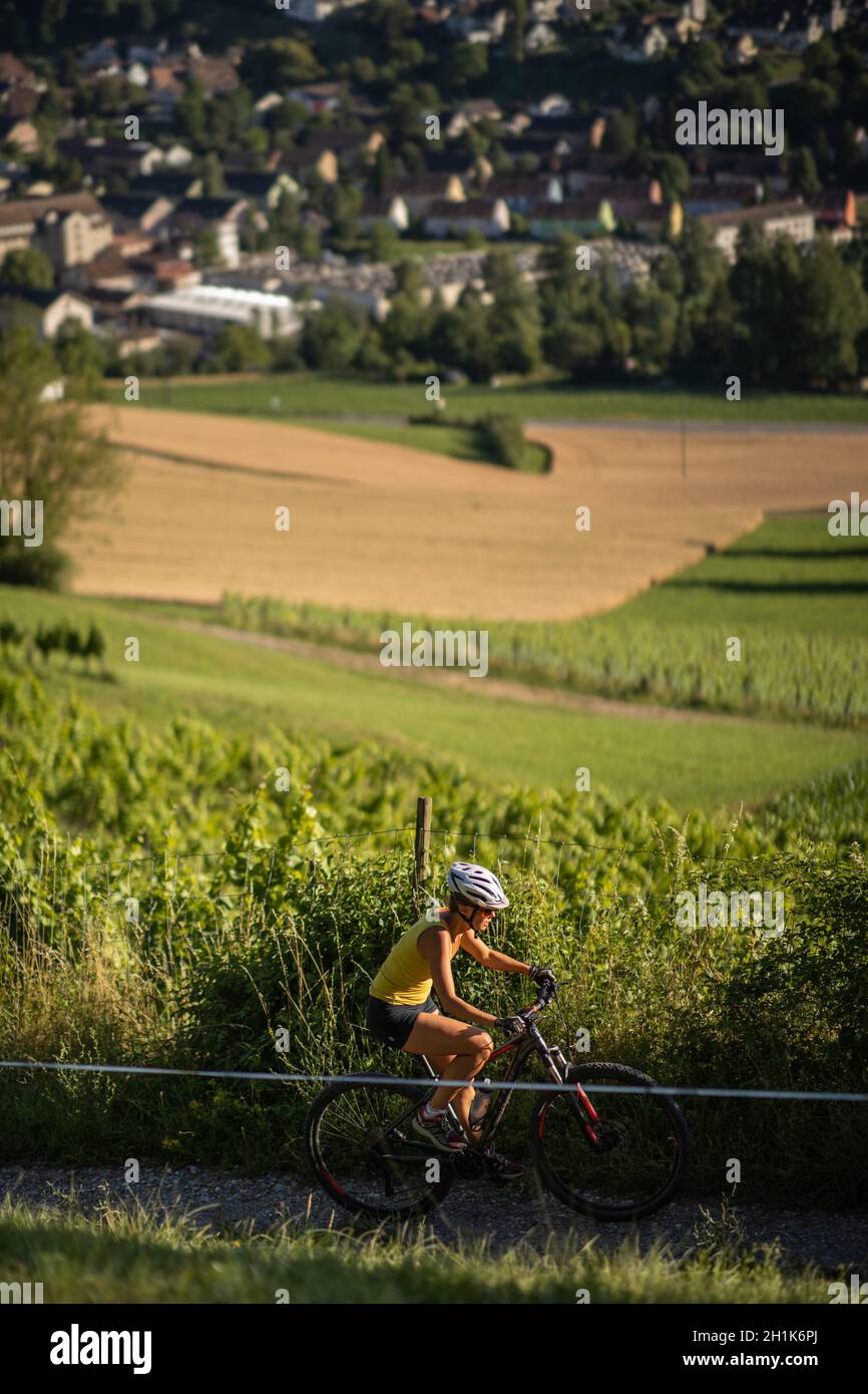 Pretty, young woman biking on a mountain bike enjoying healthy active ...