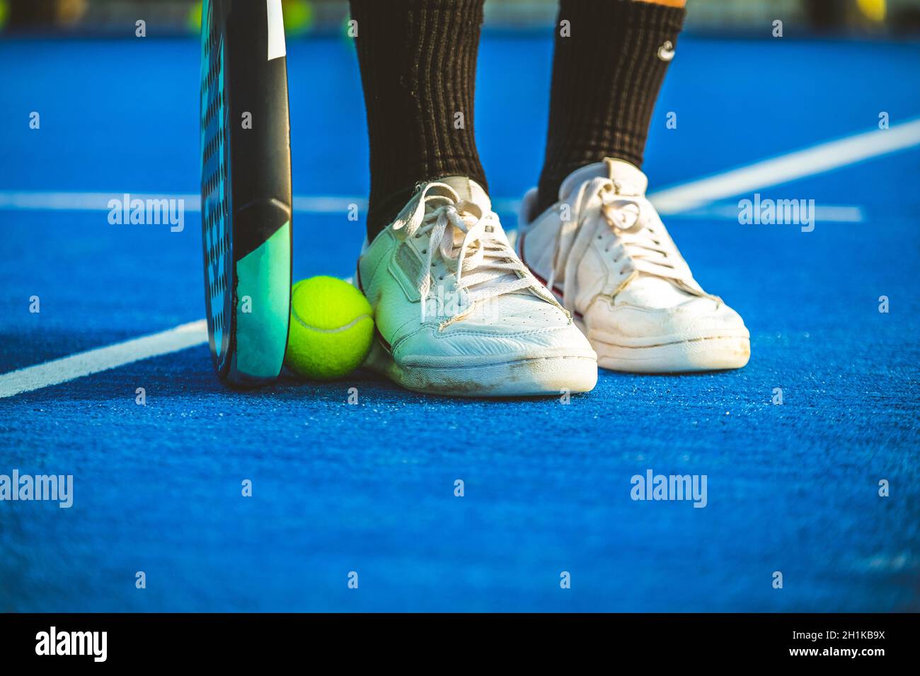 A young paddle tennis player catching the ball with the racket ...