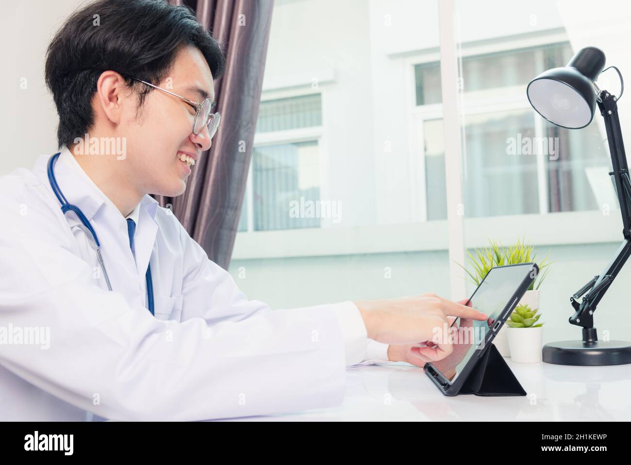 Happy Asian young doctor handsome man smile work from home office wear ...