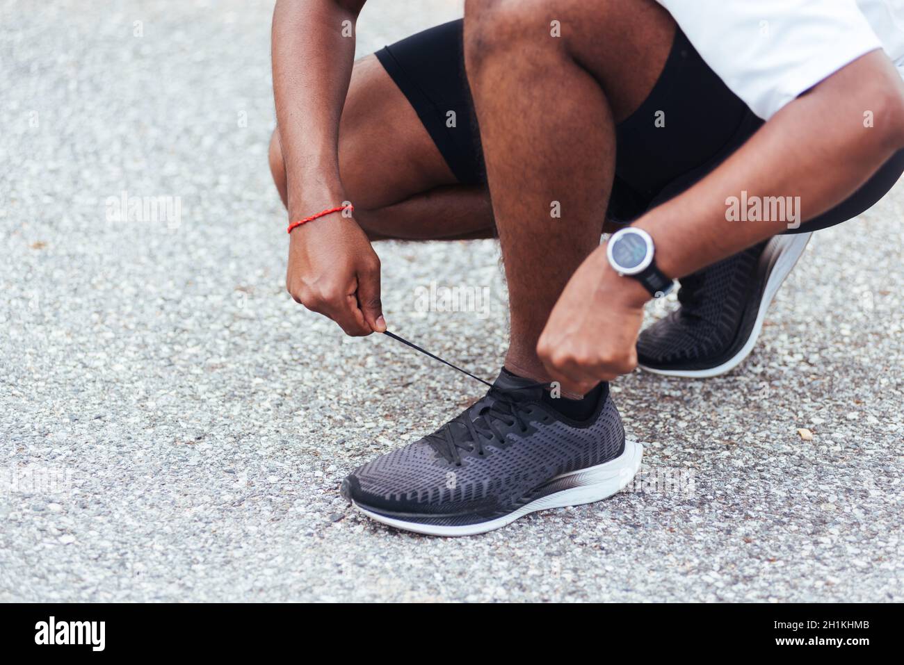 Close up Asian sport runner black man wear watch sitting he trying ...