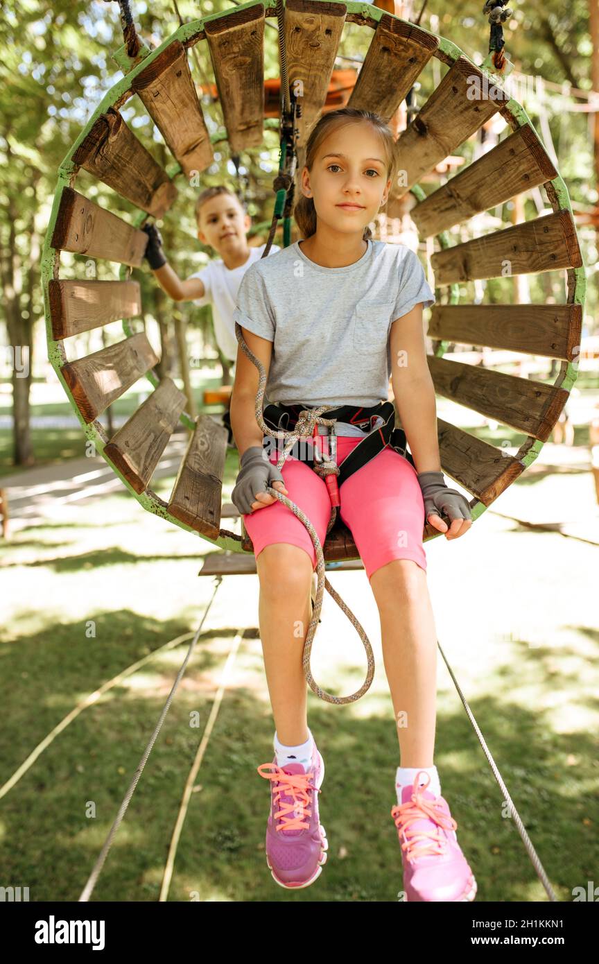 Smiling kids in equipment climbs in rope park, playground. Children ...