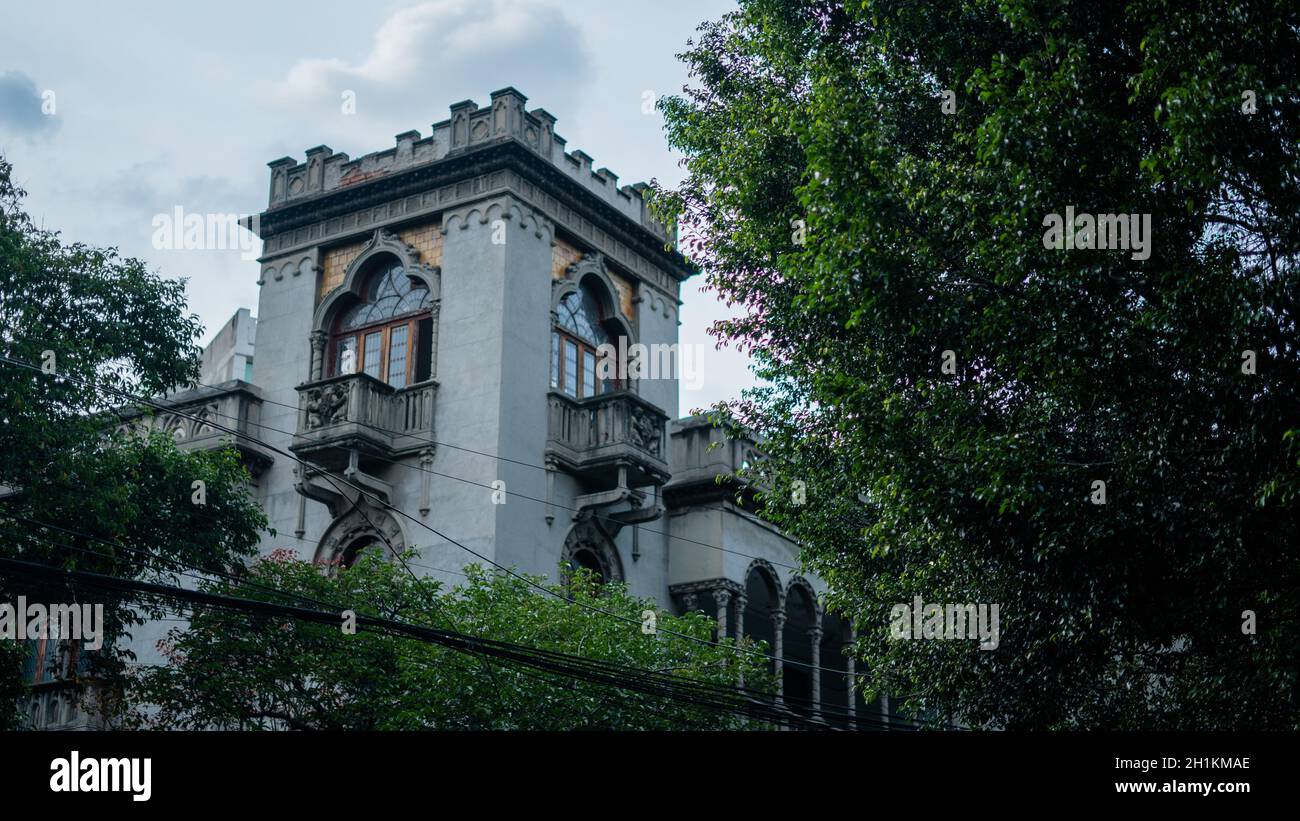 Picture of a building with medieval style architecture behind a tree ...