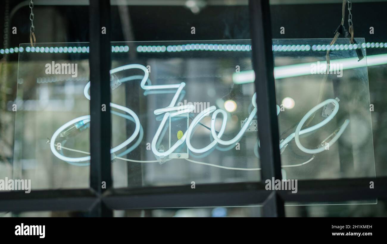 Picture of a blue Store light sign on a window from barber shop and ...