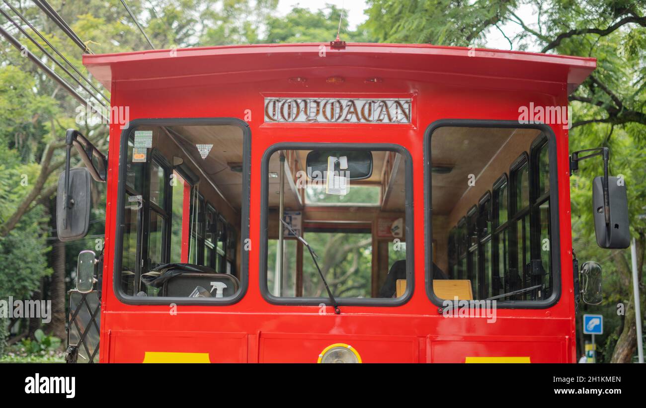 Picture of the front side of a red and yellow trolley car driving on a ...