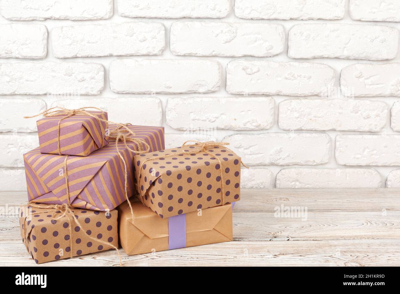 Colorful gift boxes against white brick wall background Stock Photo - Alamy