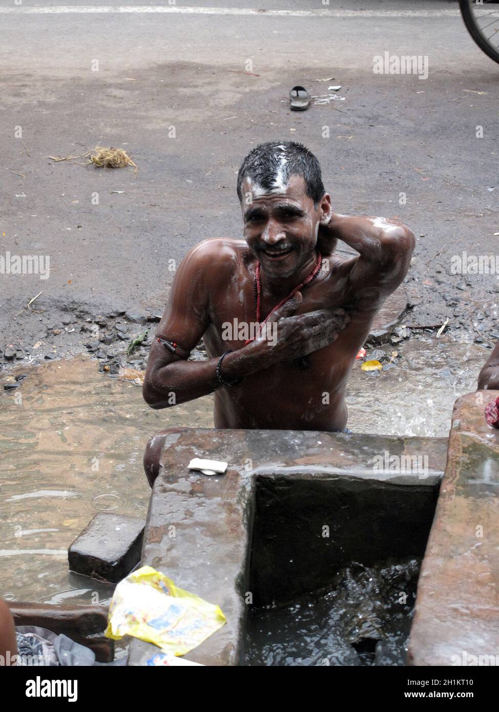 Streets of Kolkata. Indian people wash themselves on a street Stock ...