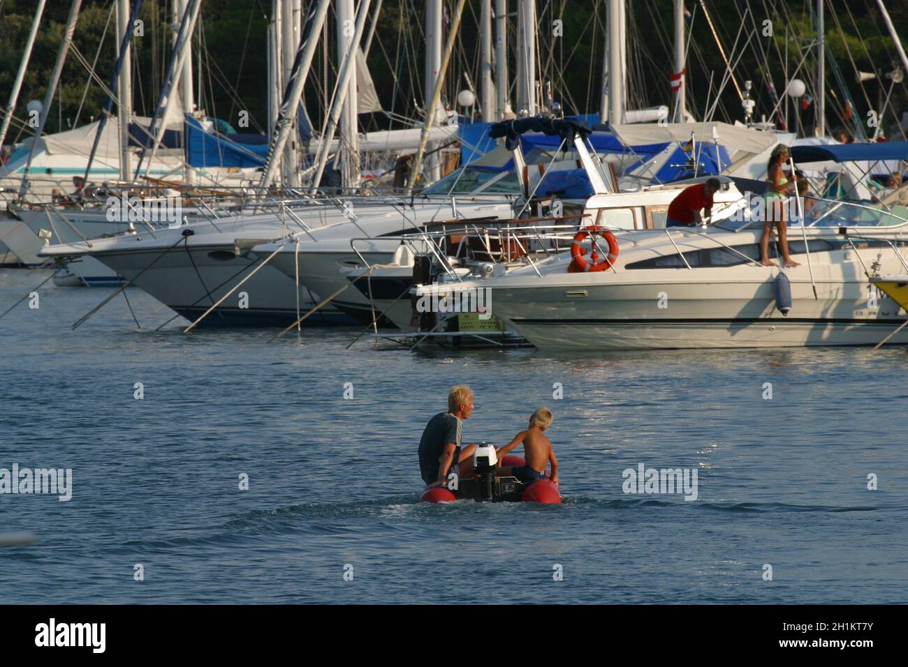 Small boat coming in full marina Stock Photo - Alamy