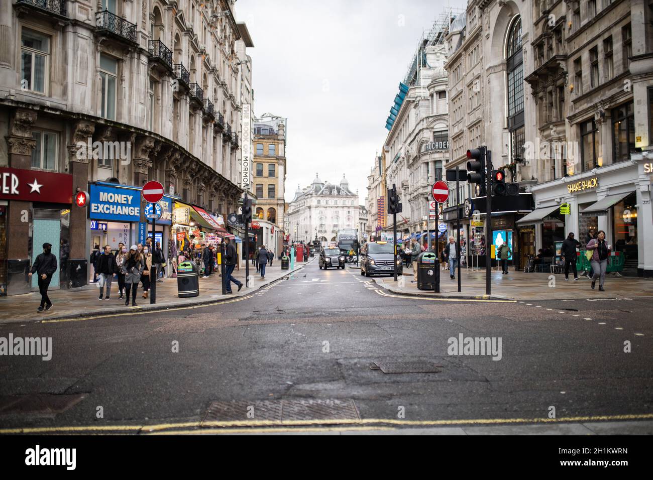 Front view of a narrow one-way street surrounded by pedestrians and ...