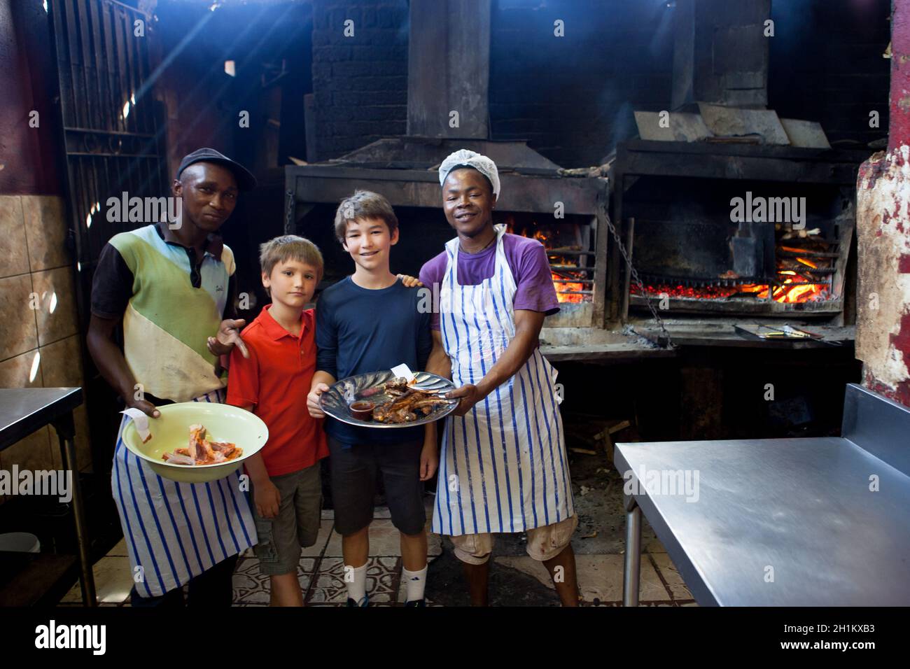 Tween boys cooking with local South Africans at Mzoli's in Gugulethu ...