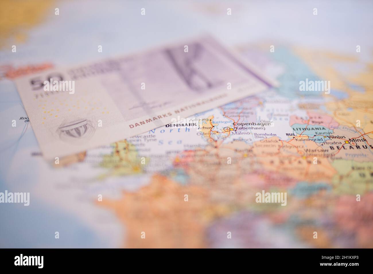 Fifty Danish kroner bill above Denmark on a colorful map of Europe with ...