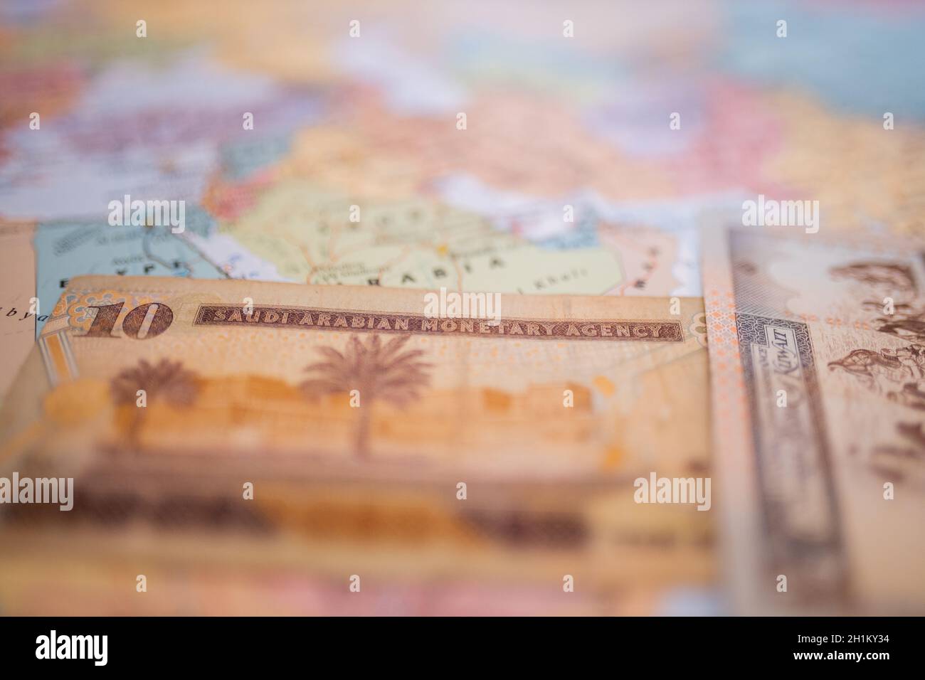 Close up picture of a Ten Saudi riyals bill next to a Kuwait Quarter ...