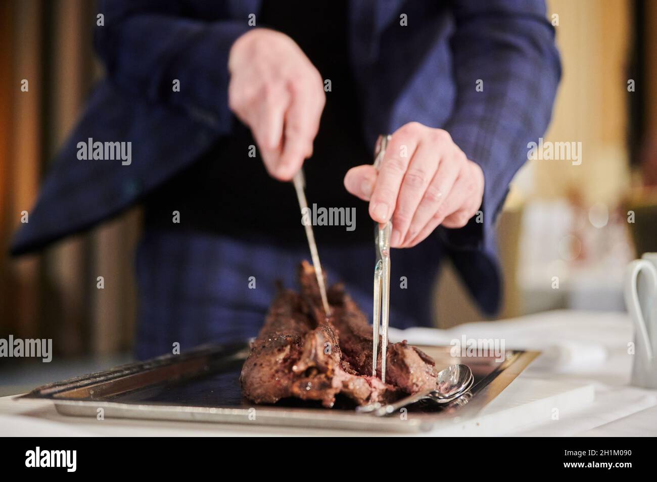 Berlin, Germany. 18th Oct, 2021. A waitress carves a saddle of venison ...