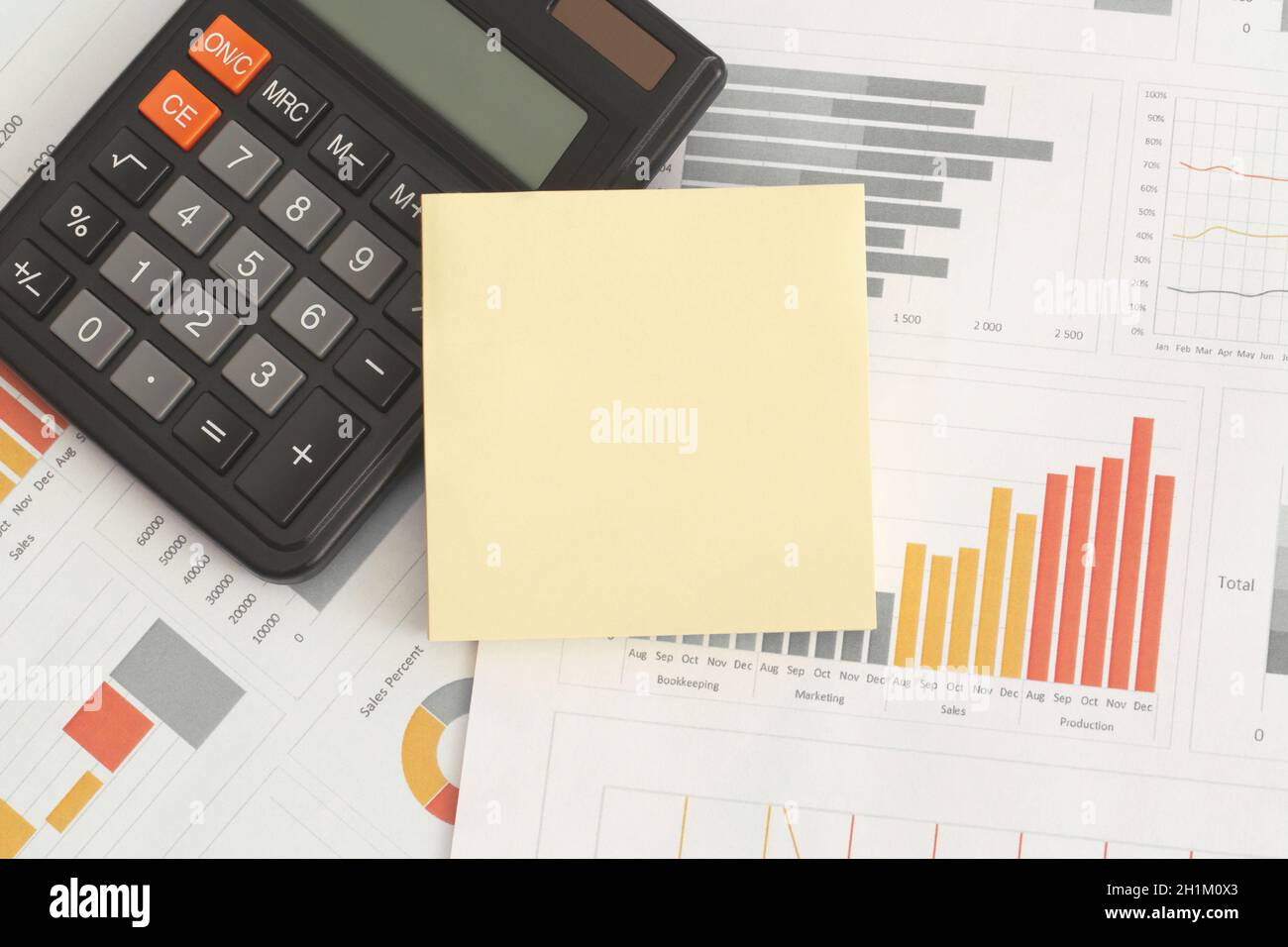 Business graphs, charts, sticky notes and calculator on table ...