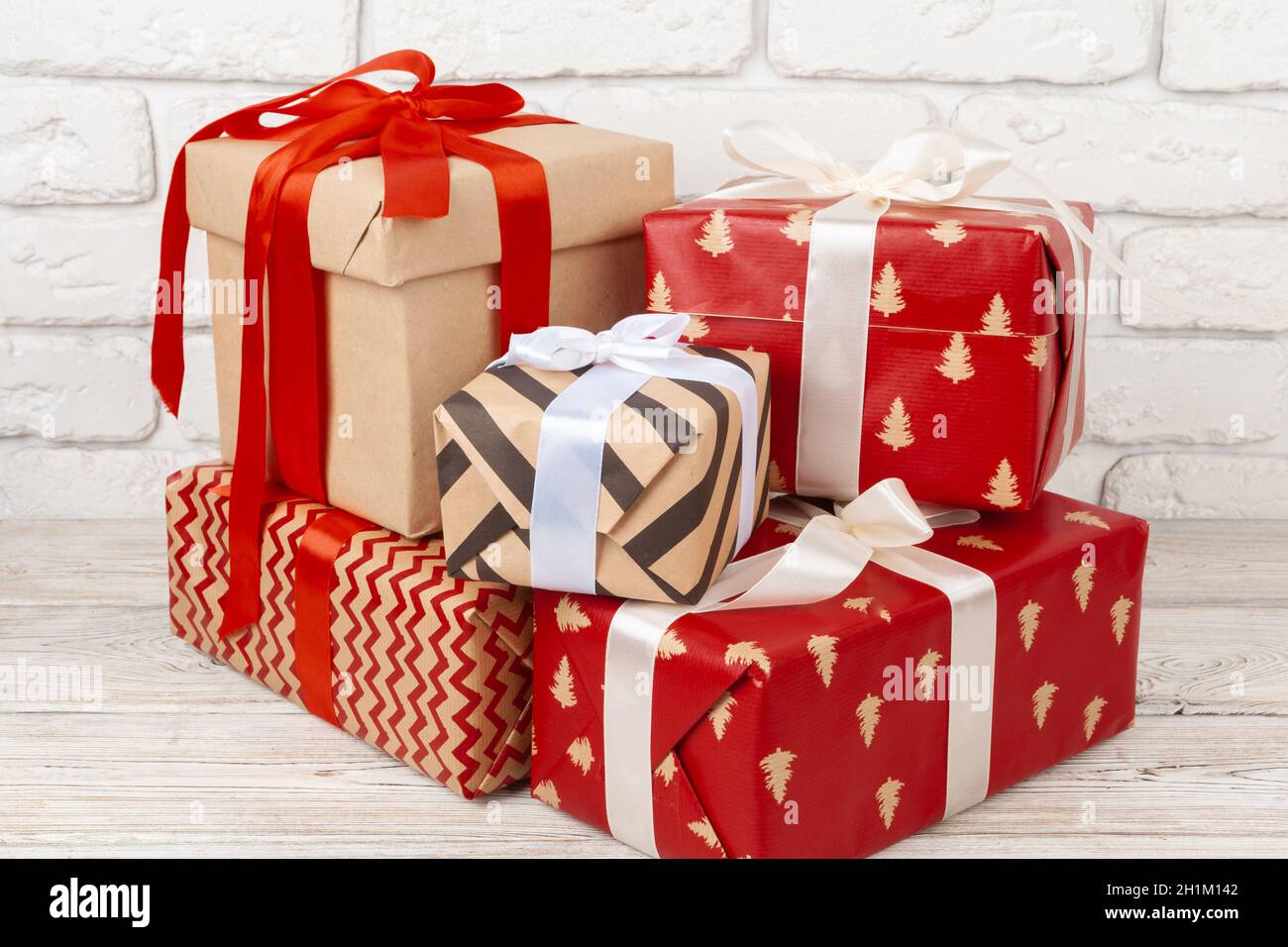 Colorful gift boxes against white brick wall background Stock Photo - Alamy