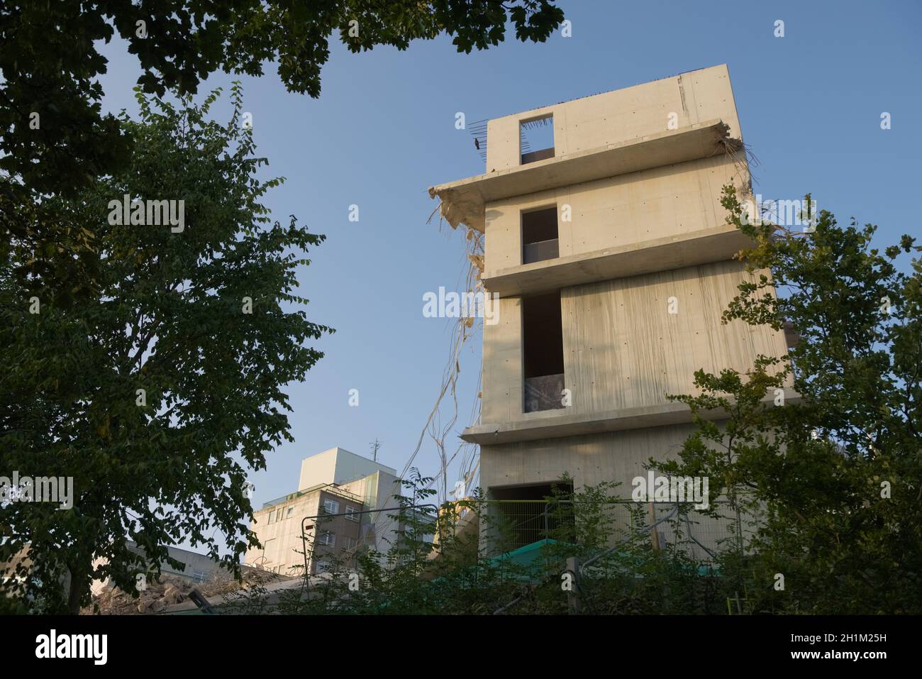 Ruined large concrete building undergoing demolition. Wider angle with ...