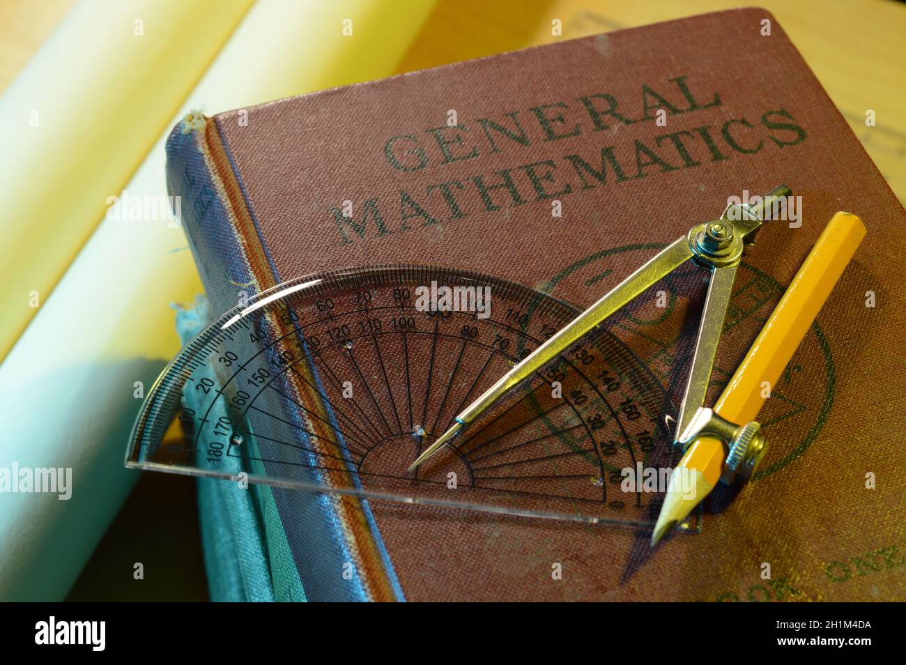 A closeup of a general mathematics school book and a compass and ...