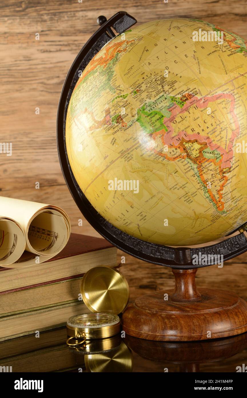 A vertical image of a world globe and paper maps for the avid traveler ...
