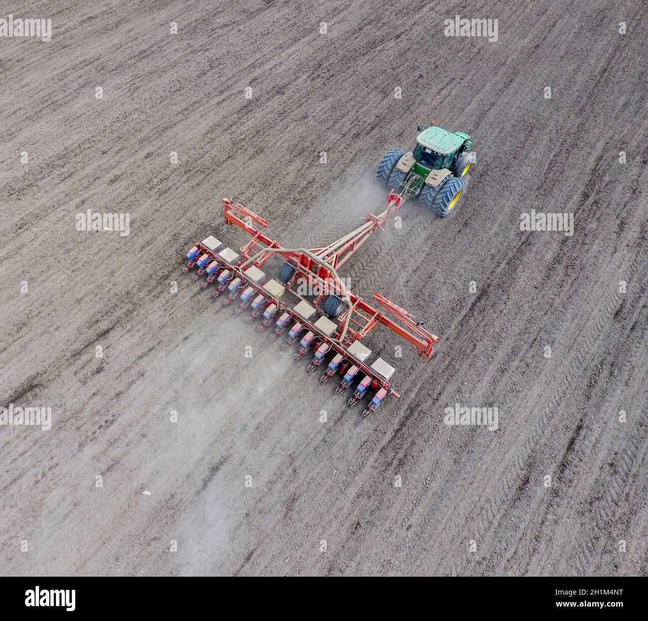 Sowing of corn. Tractor with a seeder on the field. Using a seeder for ...