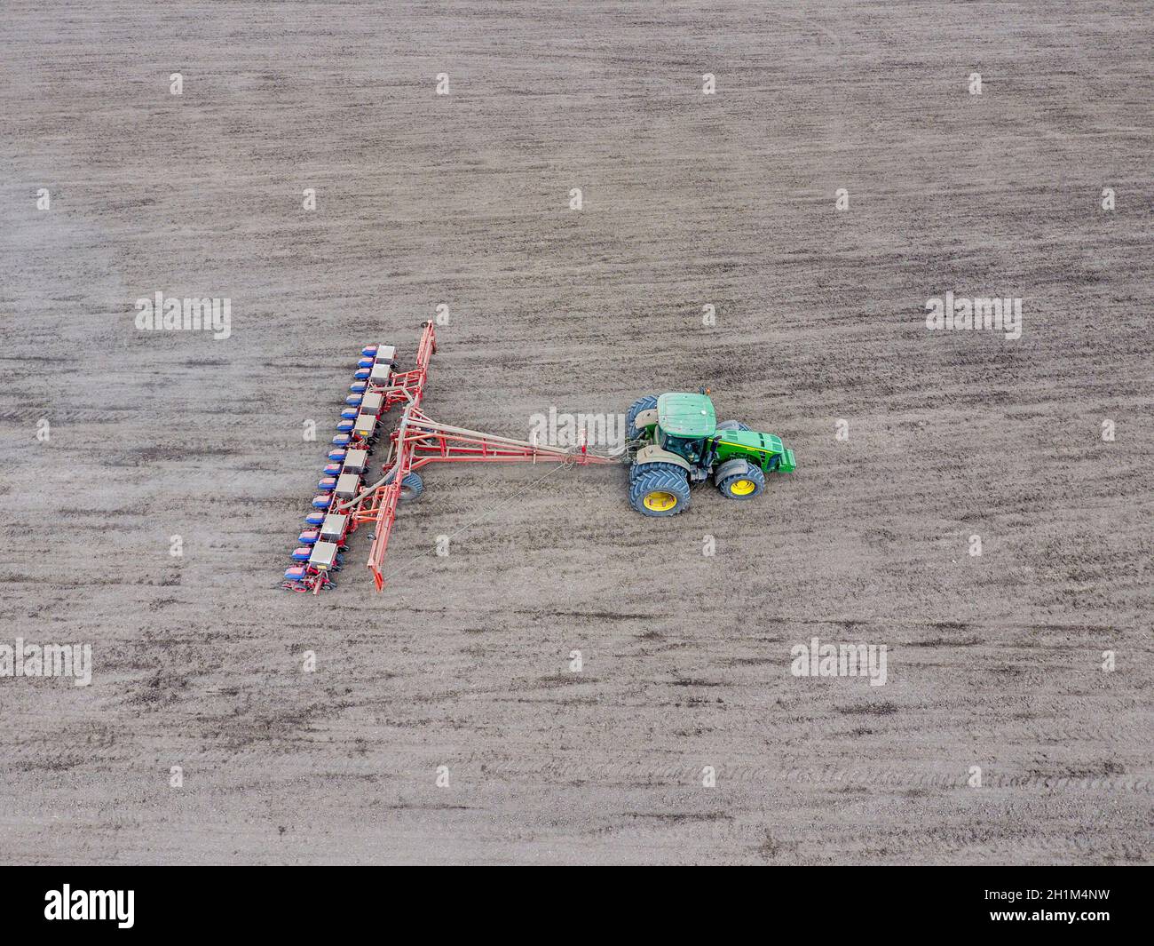Sowing of corn. Tractor with a seeder on the field. Using a seeder for ...