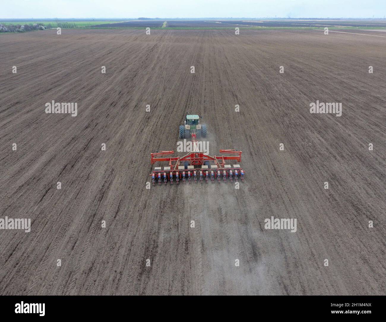 Sowing of corn. Tractor with a seeder on the field. Using a seeder for ...