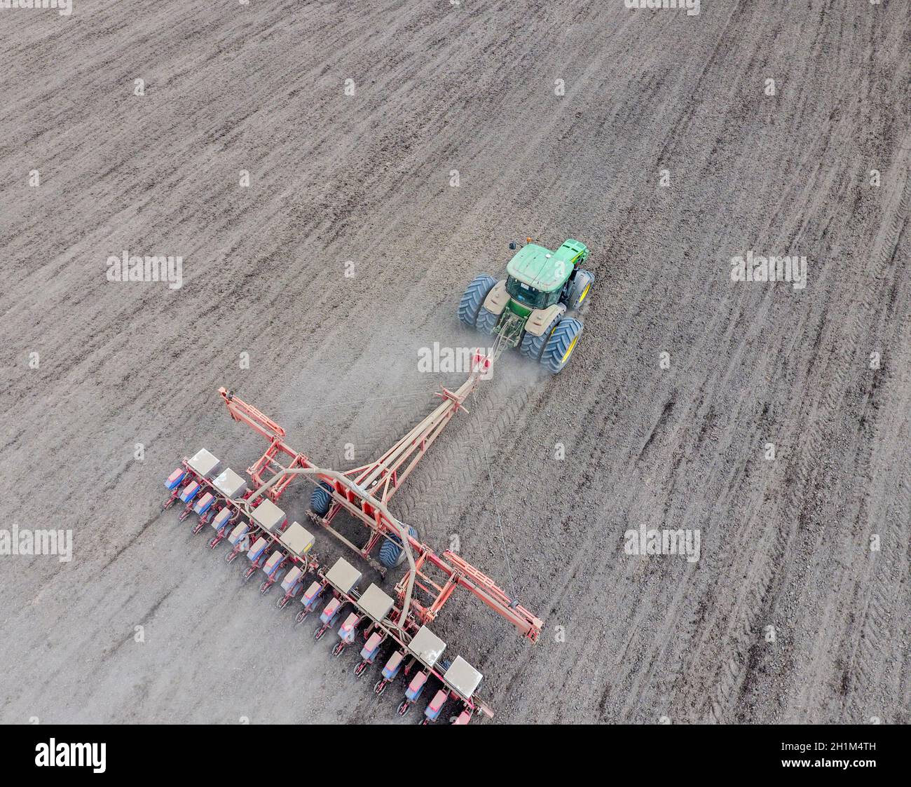 Sowing of corn. Tractor with a seeder on the field. Using a seeder for ...