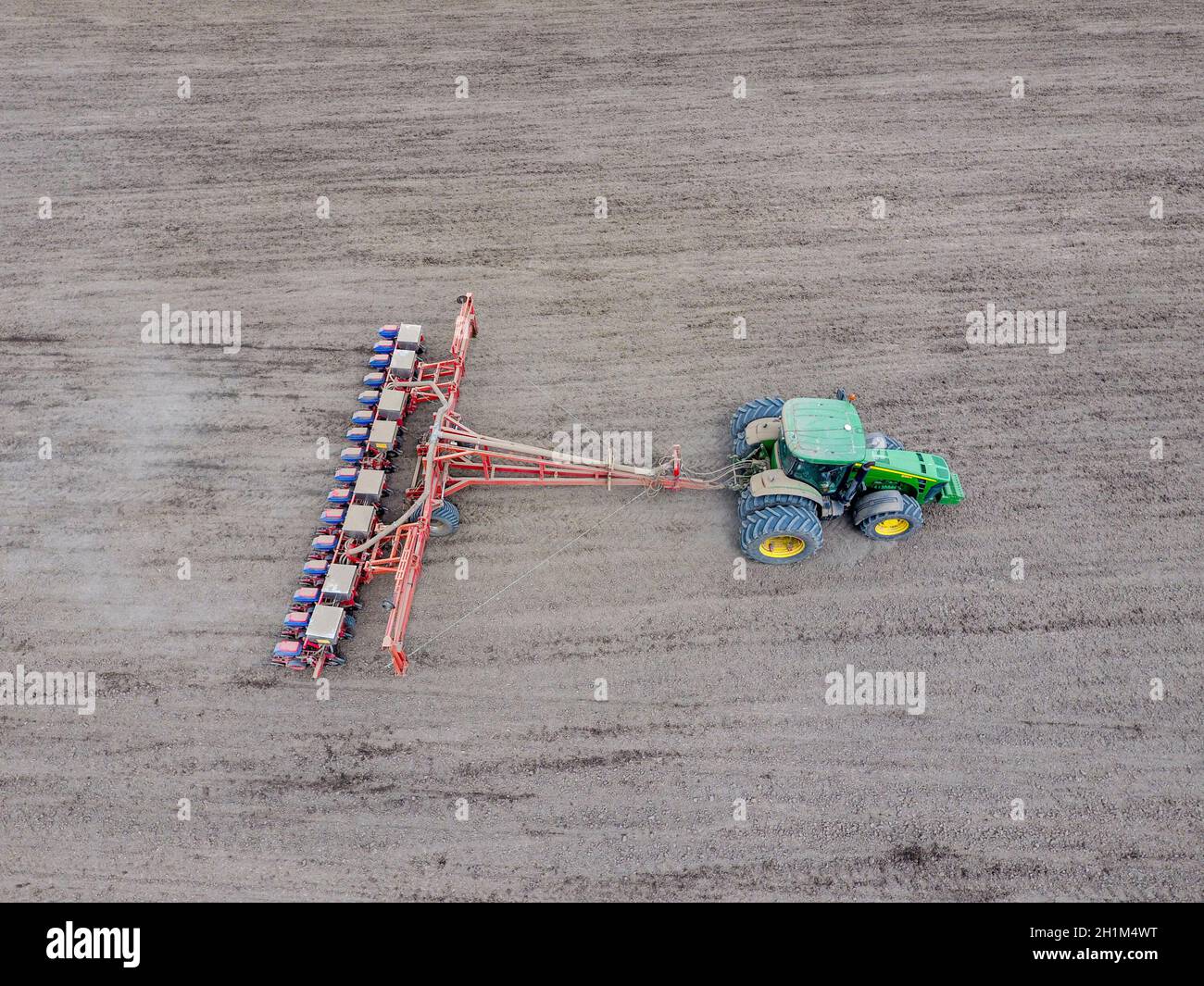 Sowing of corn. Tractor with a seeder on the field. Using a seeder for ...