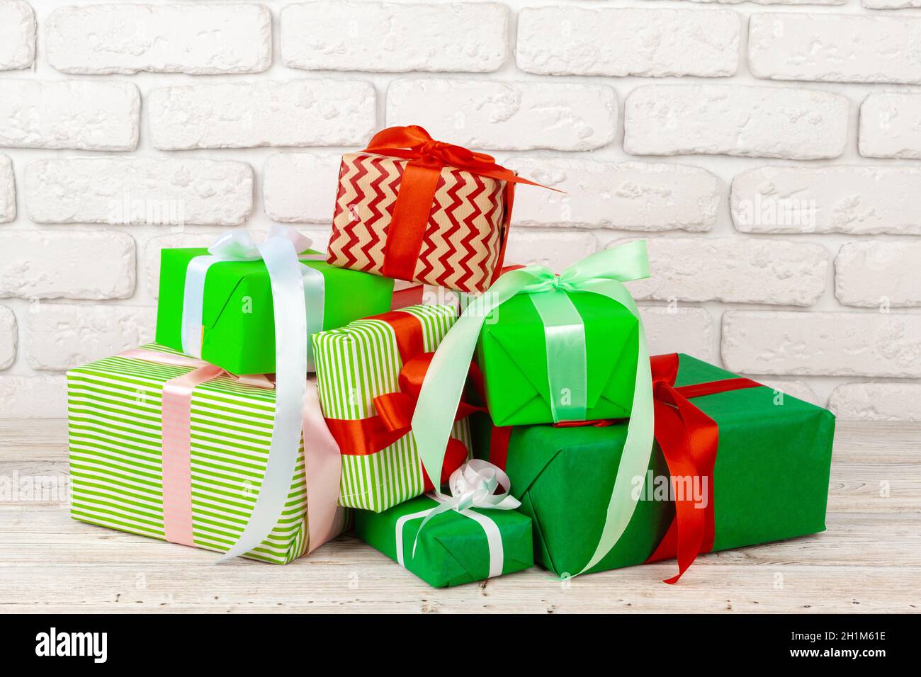 Colorful gift boxes against white brick wall background Stock Photo - Alamy
