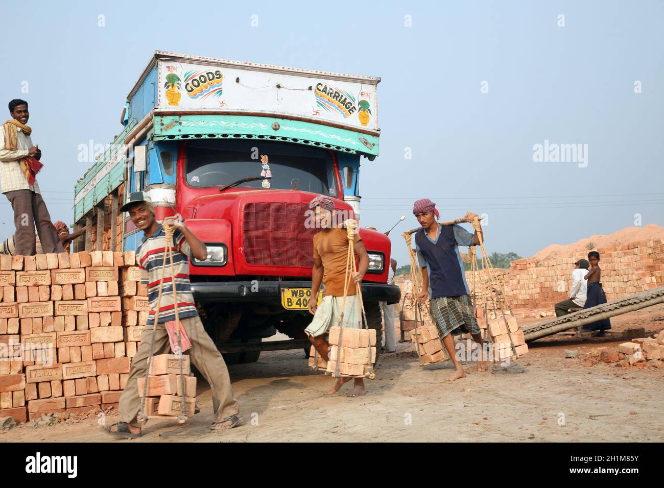 Brick field workers carrying complete finish brick from the kiln, and ...