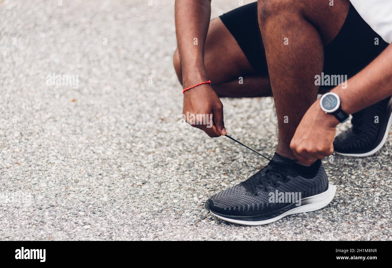 Close up Asian sport runner black man wear watch sitting he trying ...