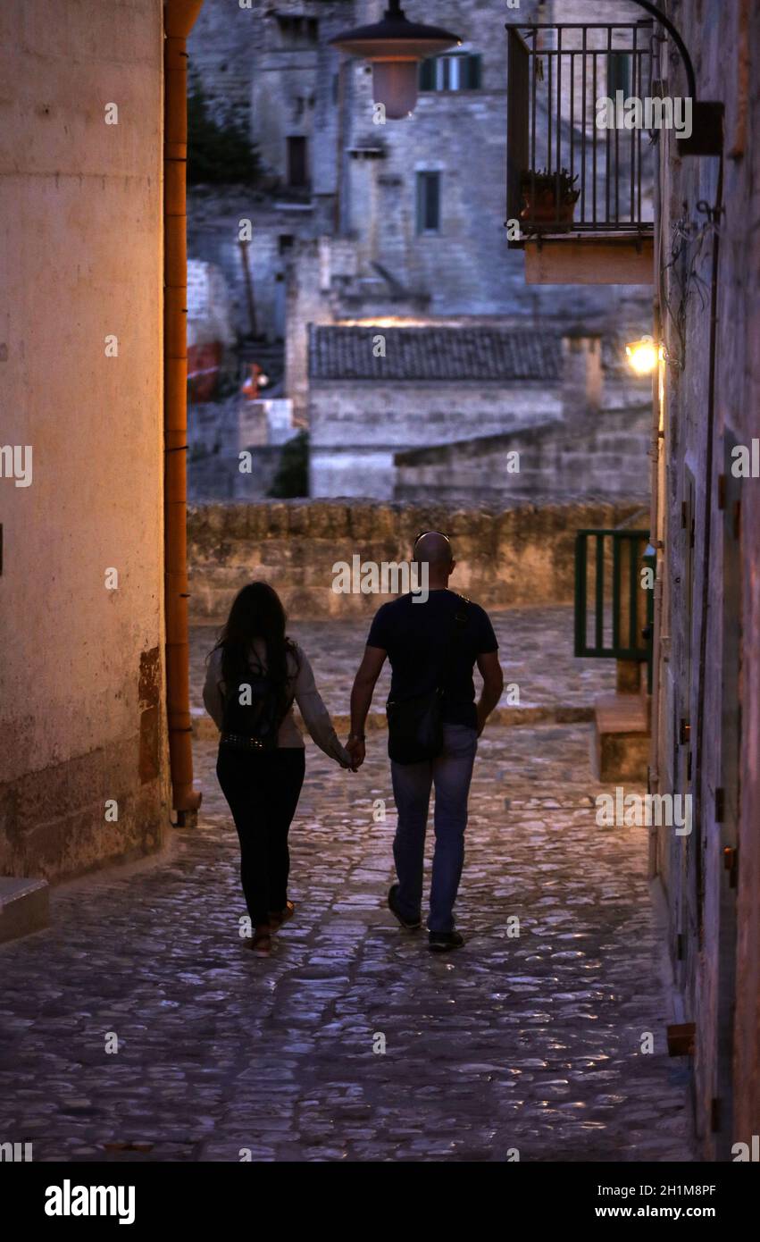 Matera, Italy - September 14, 2019: Couple during a walk on Cobblestone street in the Sassi di ...