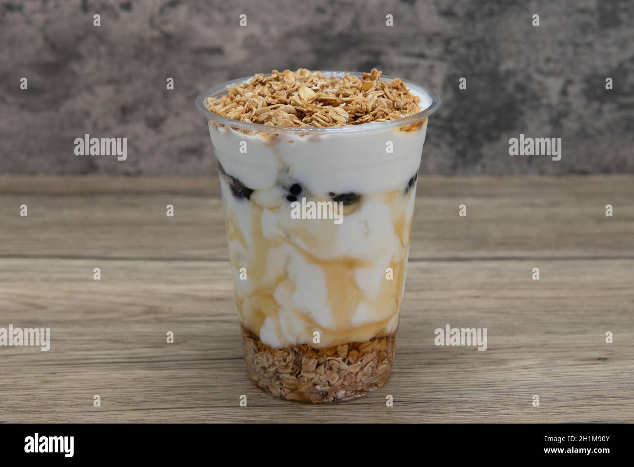 Yogurt parfait layered in a cup with fruit, oats, and nuts for a ...