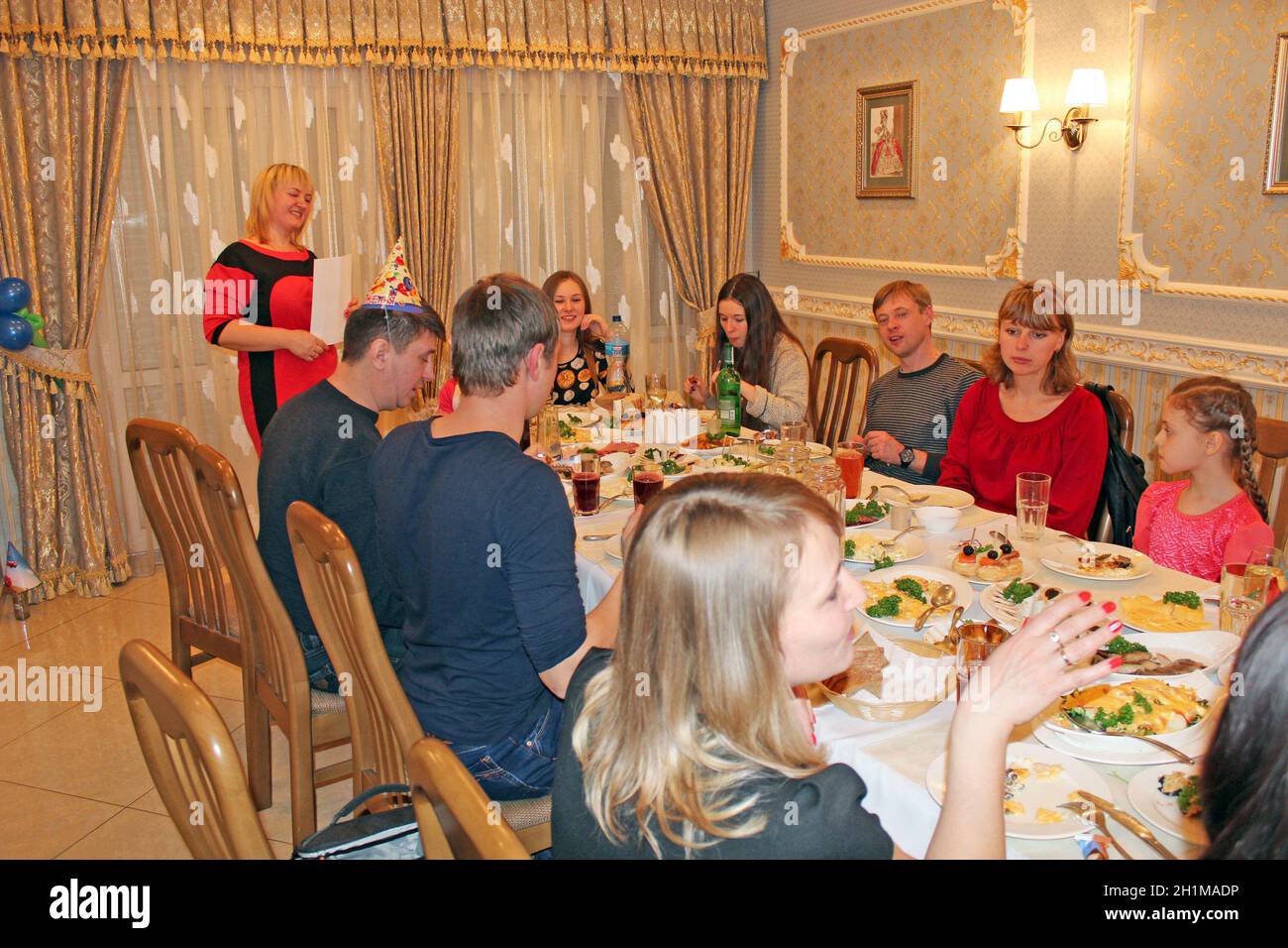 Guests gathered together at festive table. Happy people sitting at ...
